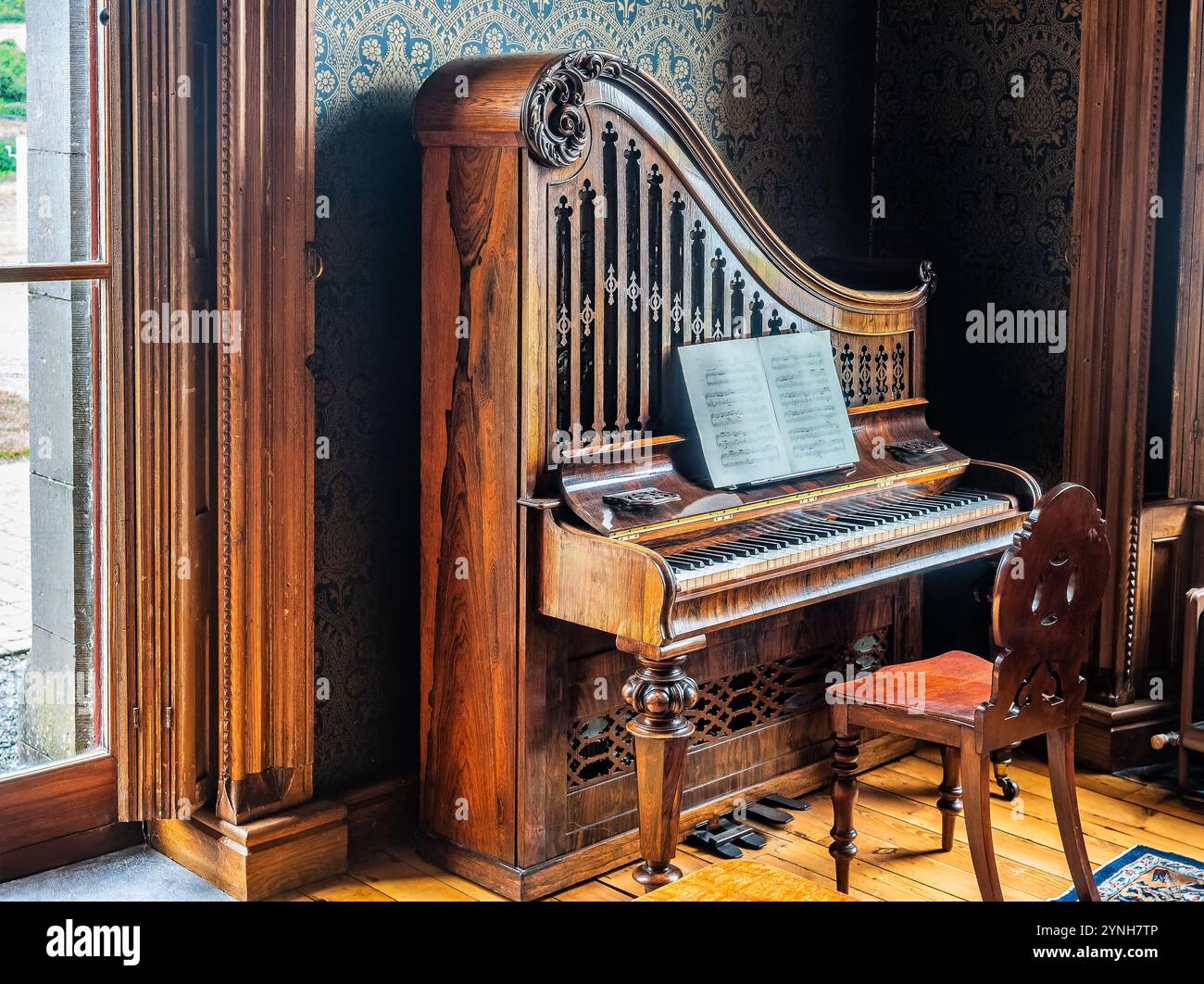 A beautifully crafted vintage piano stands in a luxurious room ...