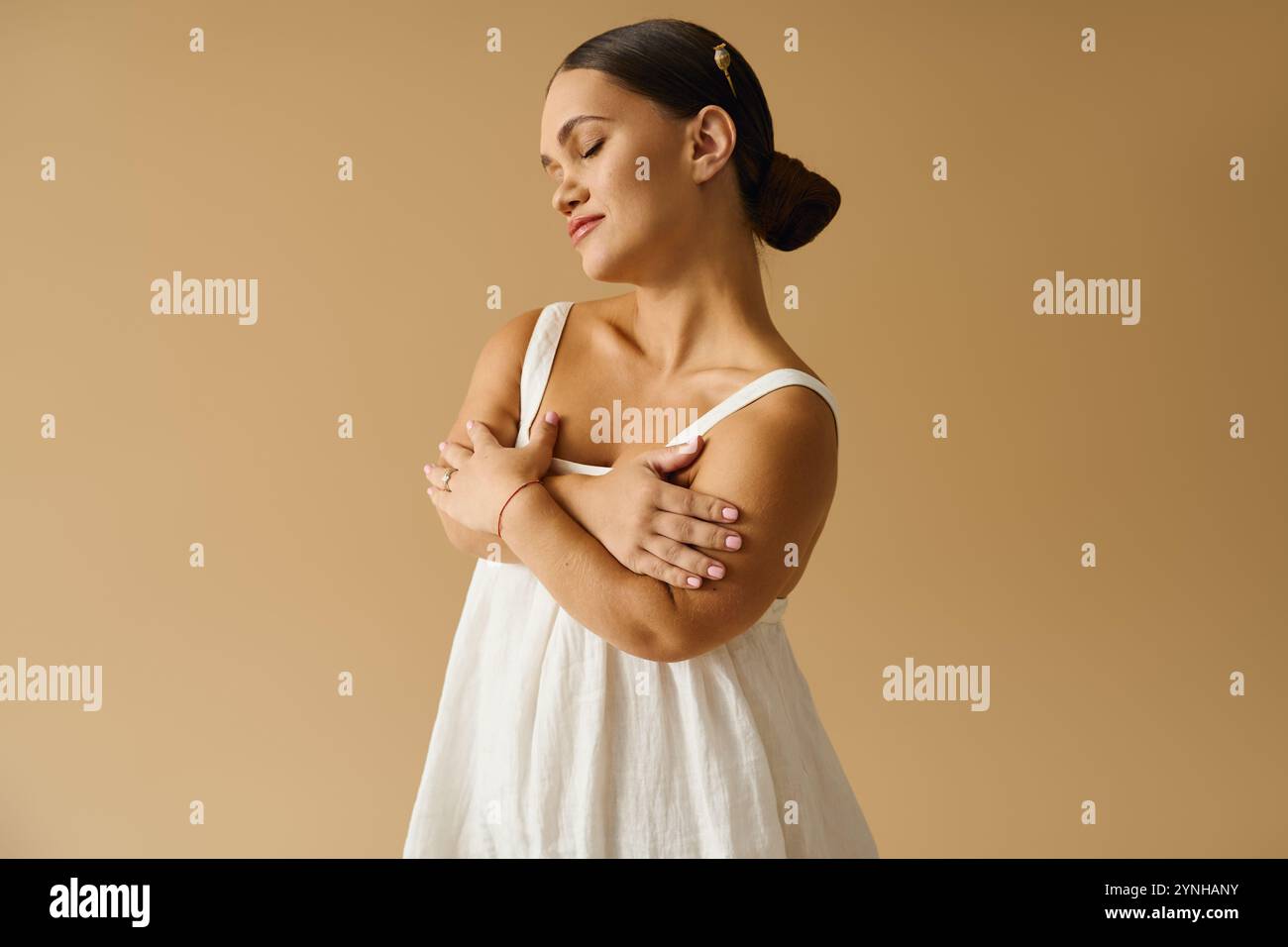 A short-statured young woman gracefully poses in a beautiful dress ...