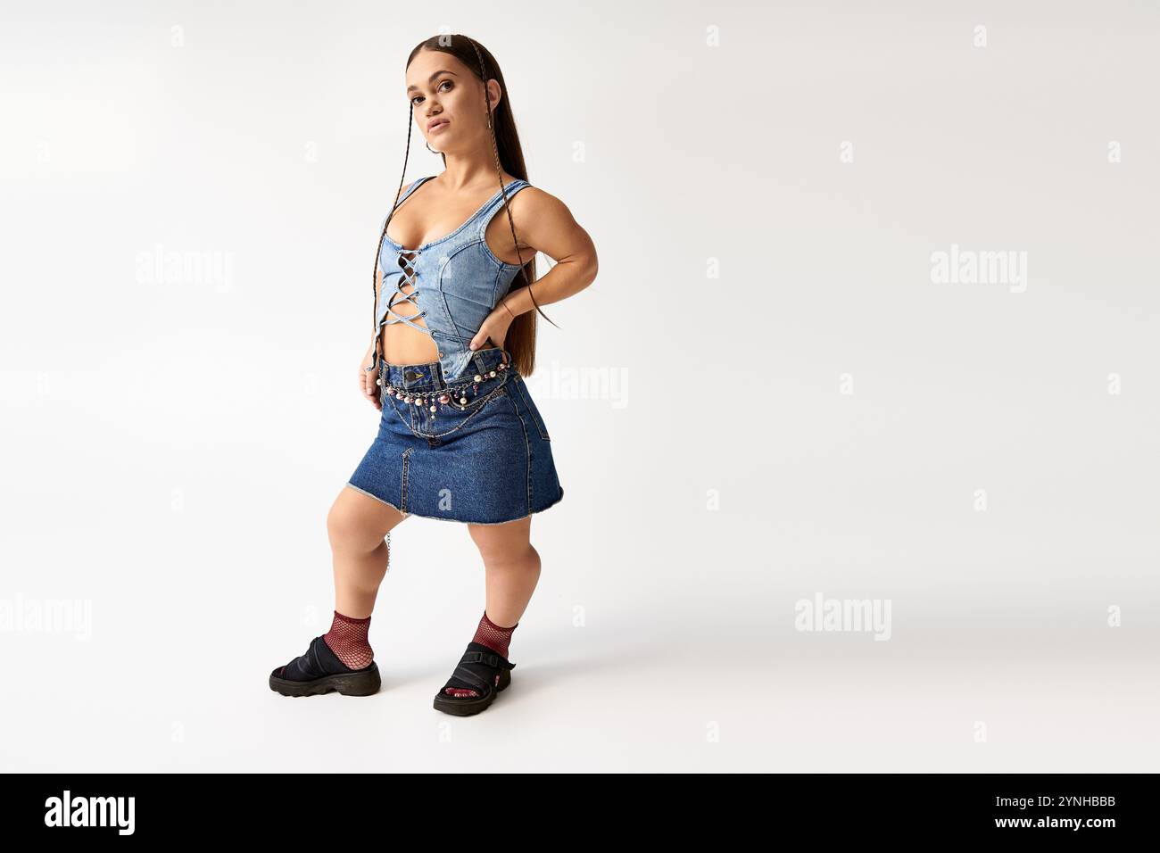 A young woman proudly showcases her fashion-forward denim outfit in a ...