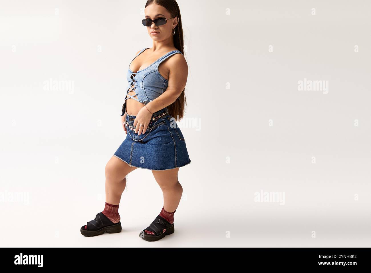 A young woman with short stature effortlessly displays her fashion ...