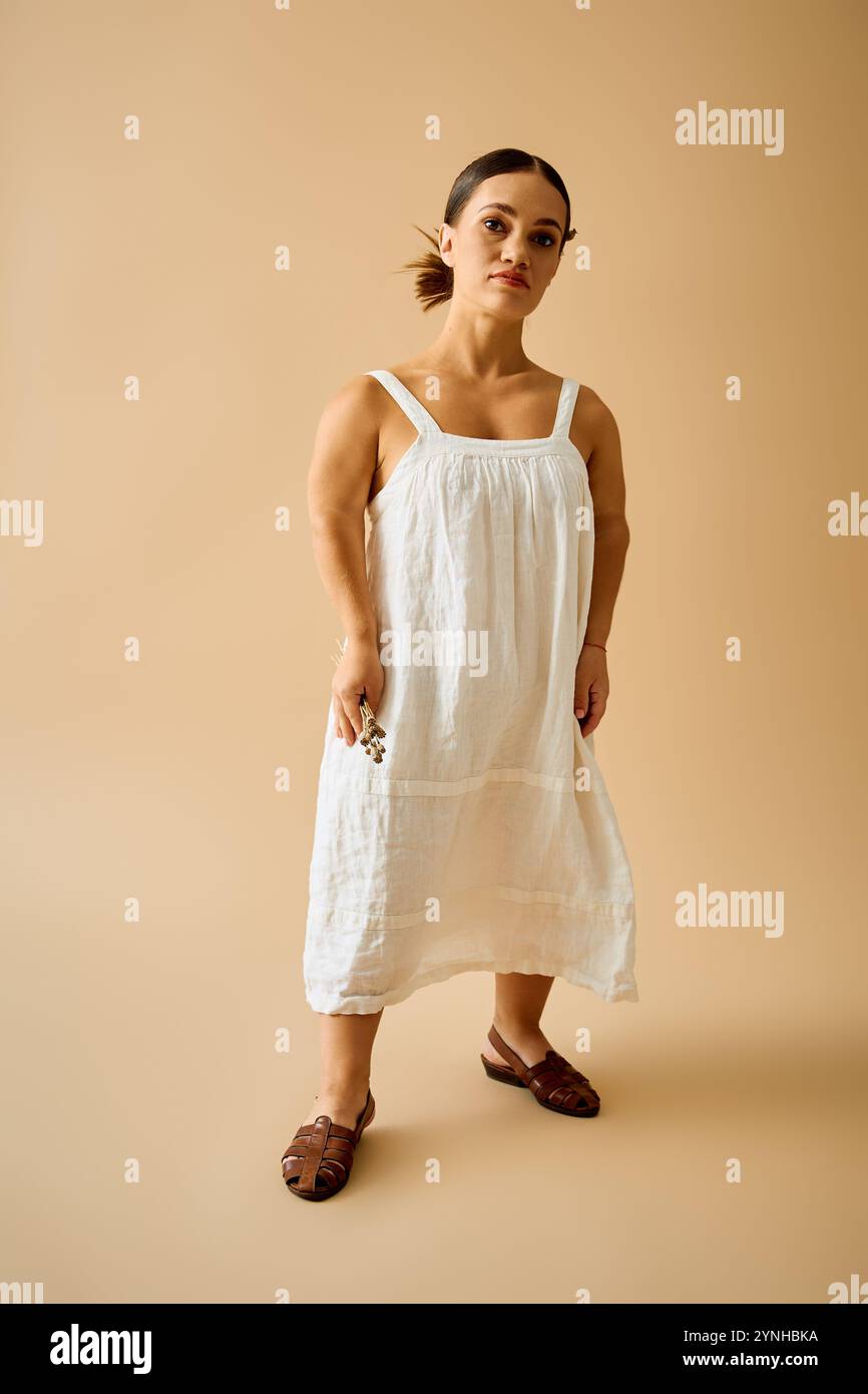 A young woman with short stature poses confidently in an elegant dress ...