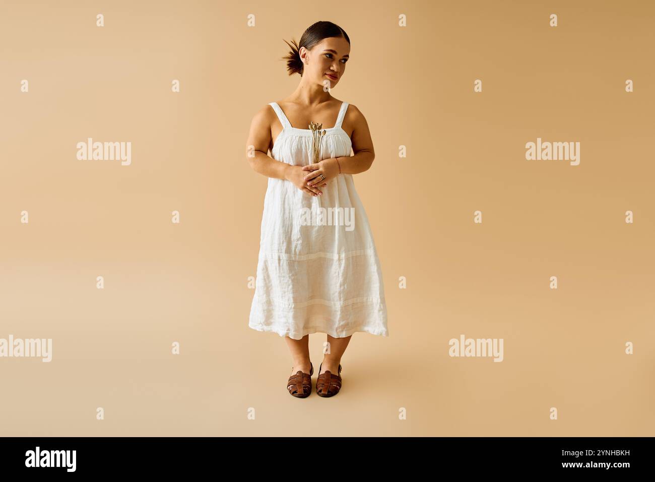 A young woman with short stature models an elegant white dress in a ...