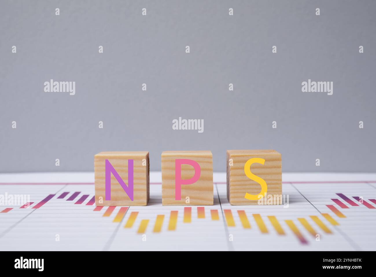 NPS (net promoter score) abbreviation made of cubes against grey ...