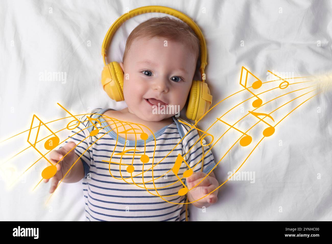 Cute little baby with headphones lying on bed, top view. Music notes ...