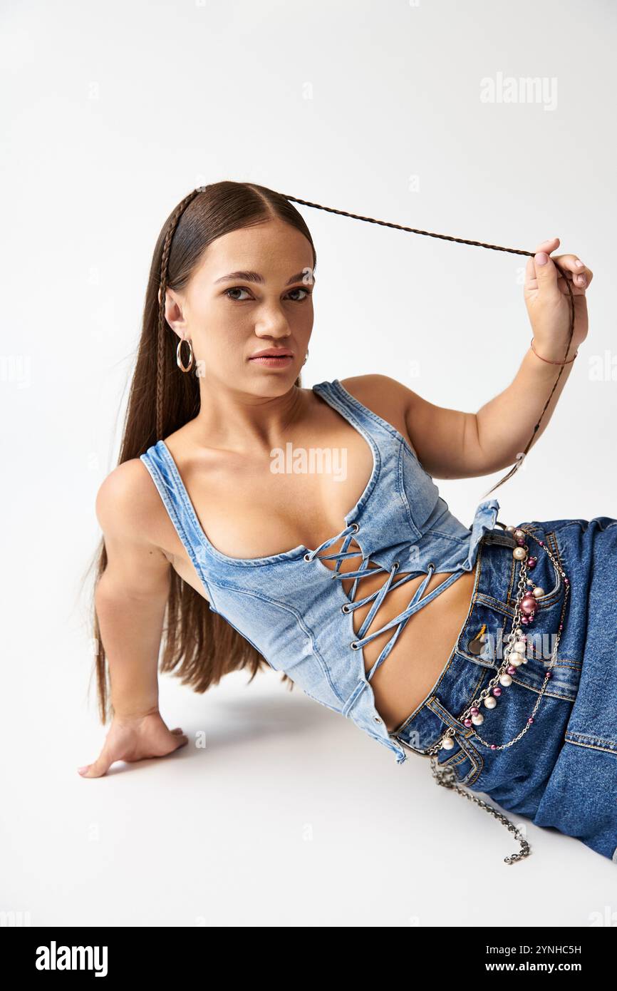 Fashionable young woman with short stature confidently poses in denim attire Stock Photo - Alamy