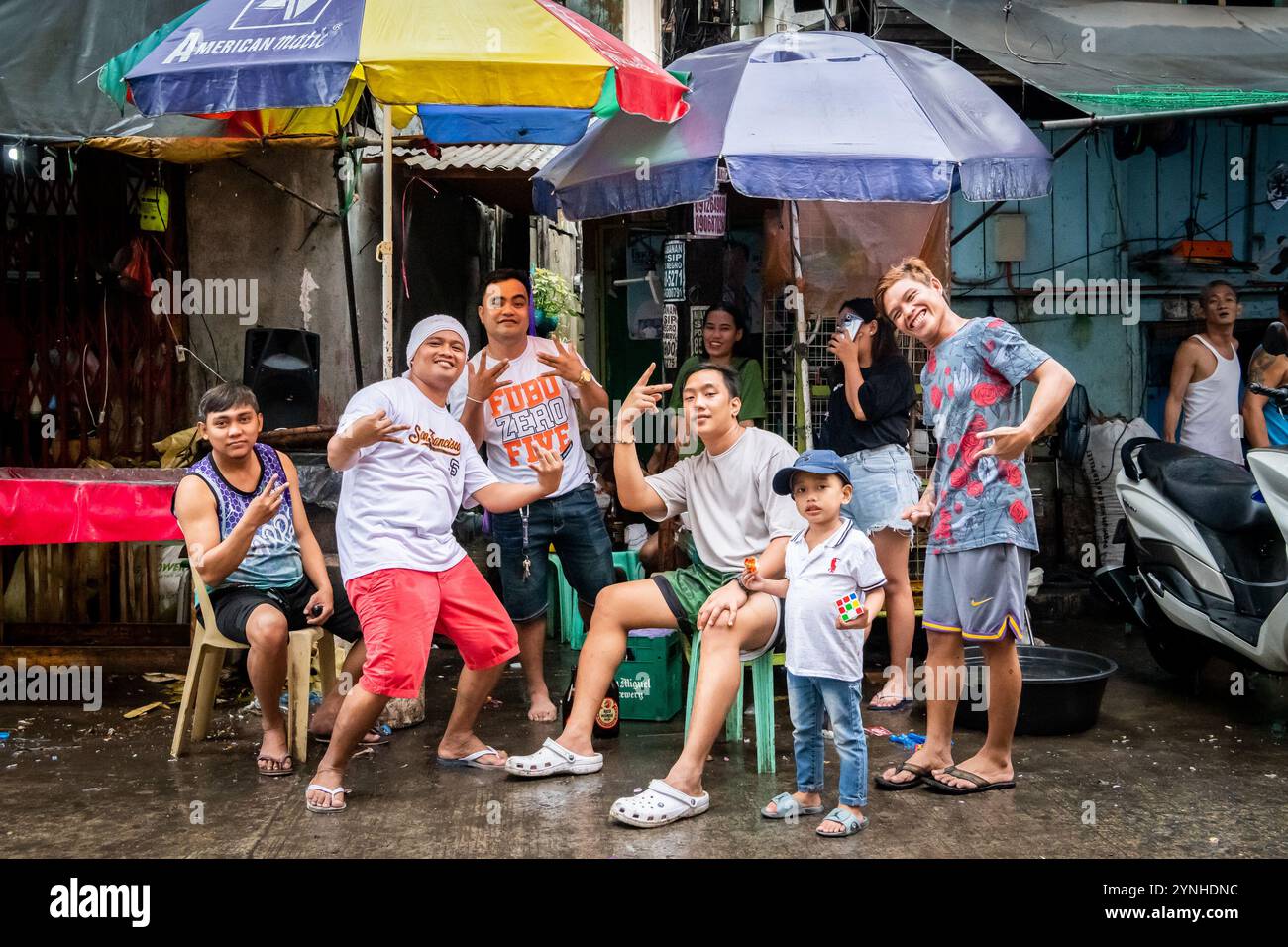 A friendly group of Filipina men and kid in a typical street in the Tondo District of Manila ...