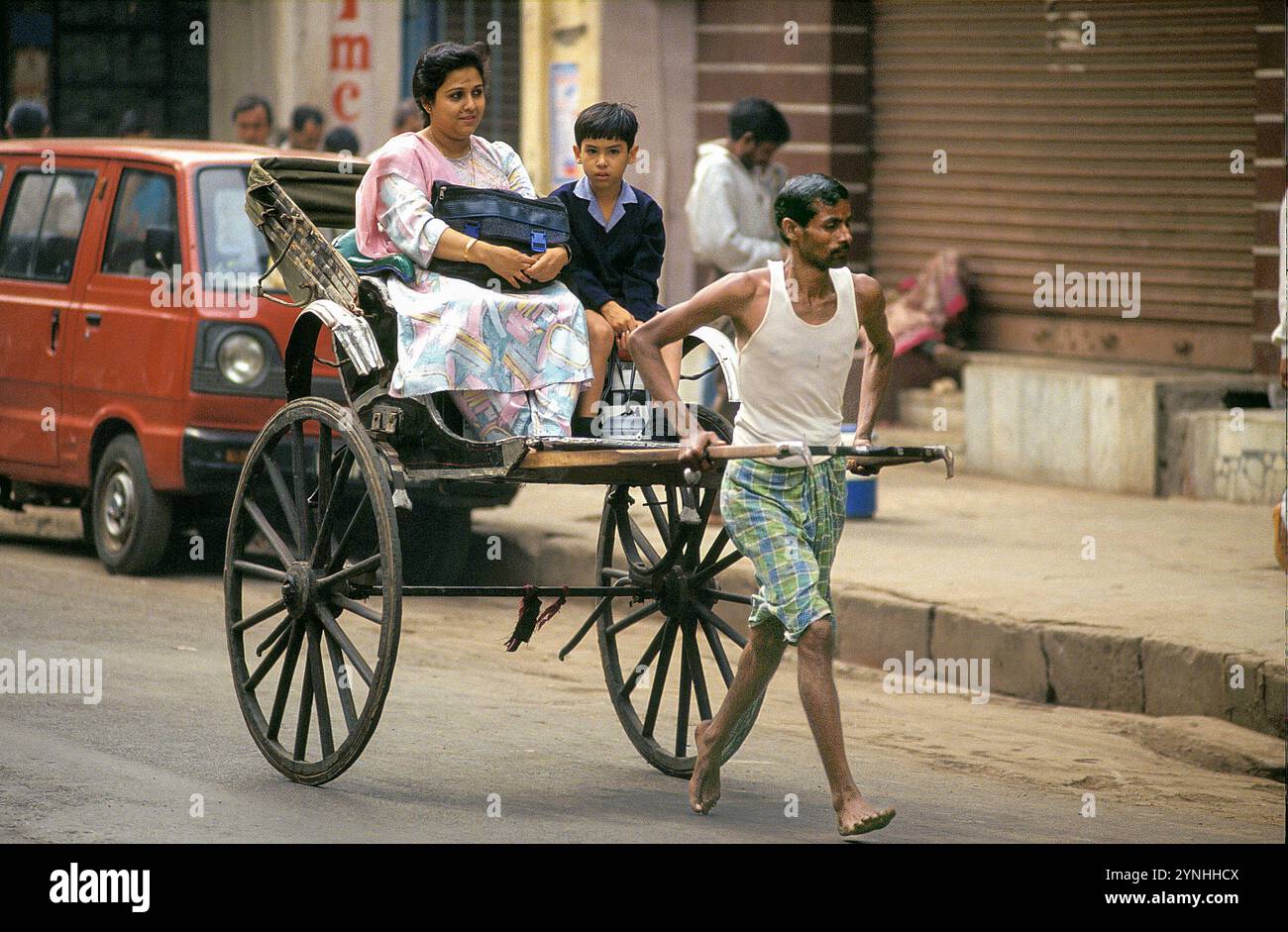 India, Calcutta, a clearly wealthy mother and son are taken away by a ...