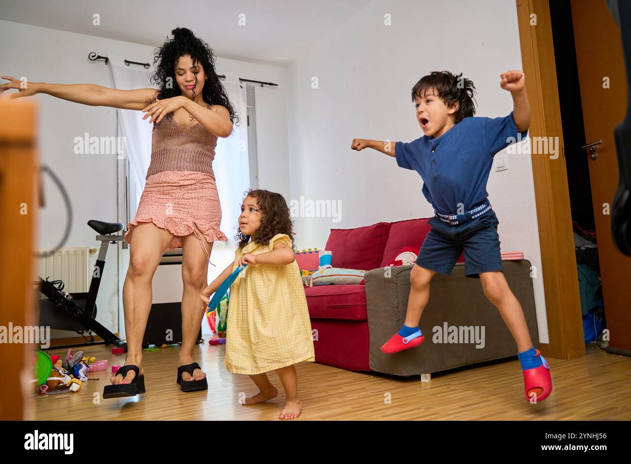 Family with two children dancing in the living room of their home Stock ...