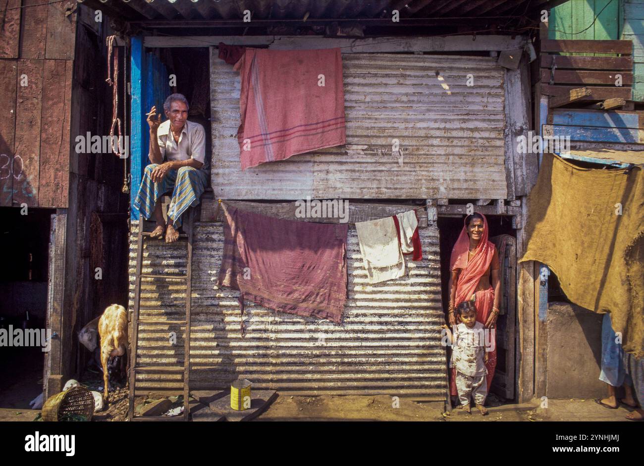 India, Bombay, family in front of their corrugated iron house in a slum ...
