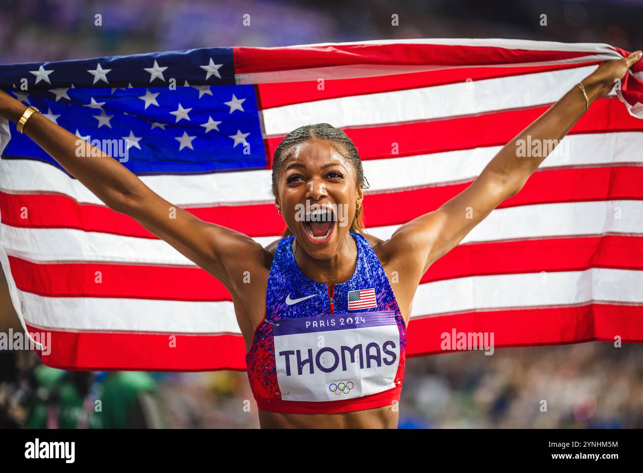 Gabrielle Thomas celebrating with her country's flag in the 200 meters ...