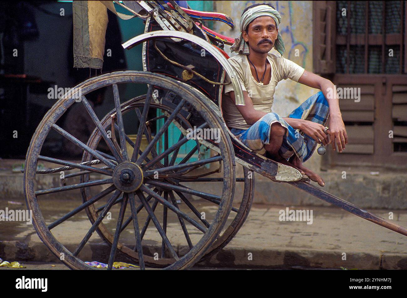 India, Calcutta, rickshaw runner waits for customers with his bell in ...