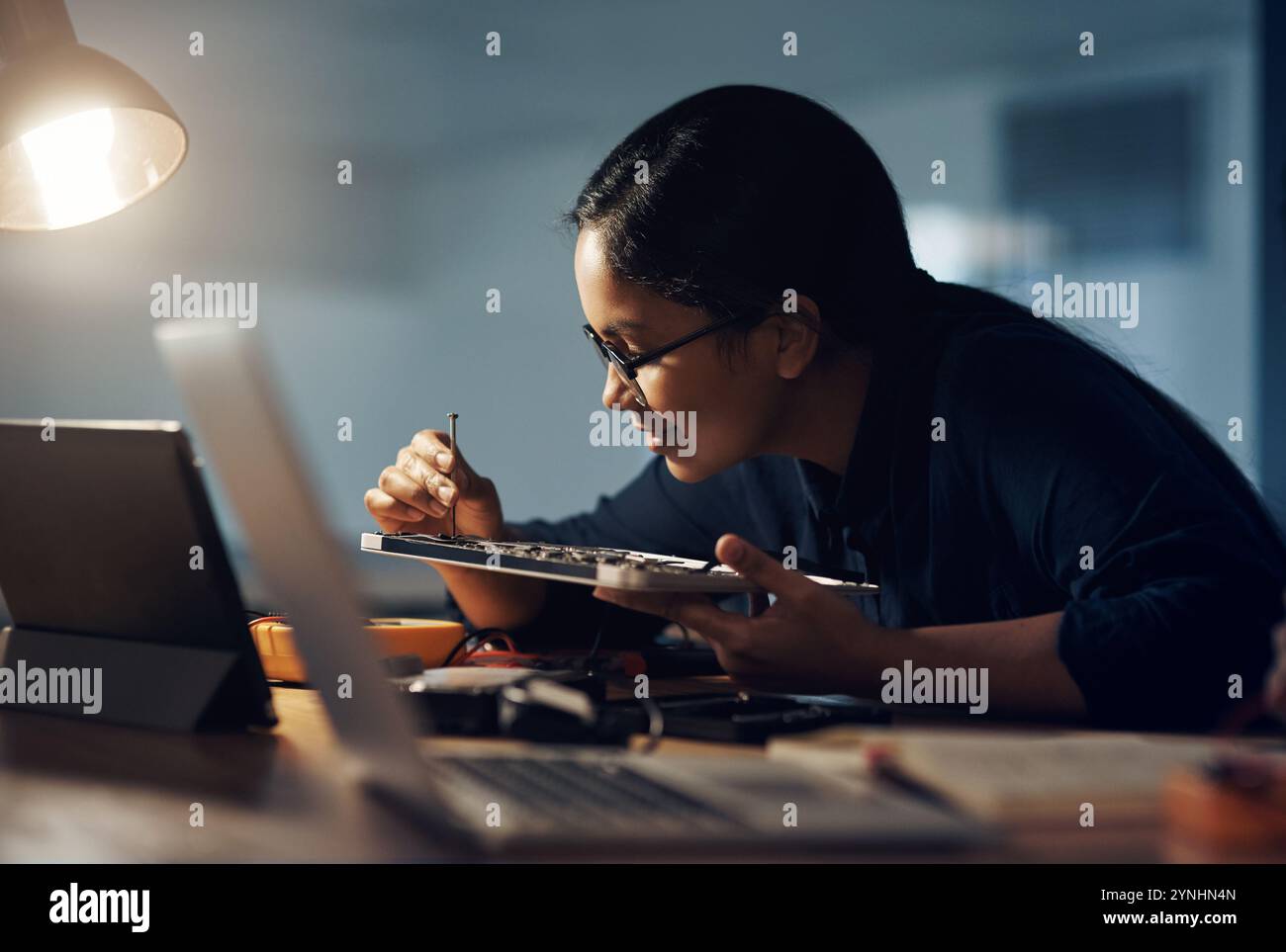 Woman, computer and technician on motherboard at night, repair circuit ...