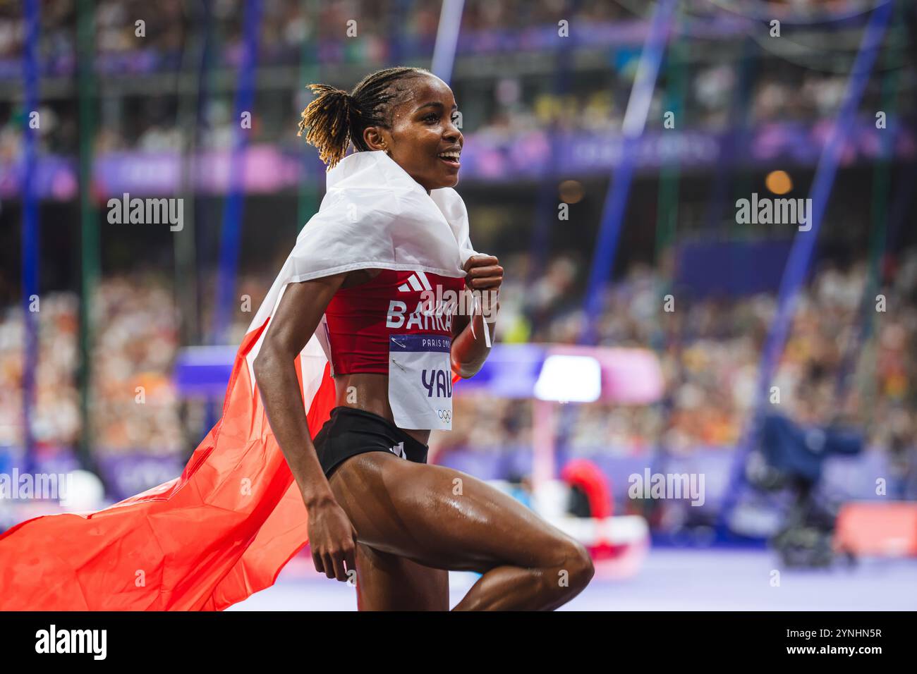 Winfred Yavi celebrating her medal with her country's flag at the Paris ...