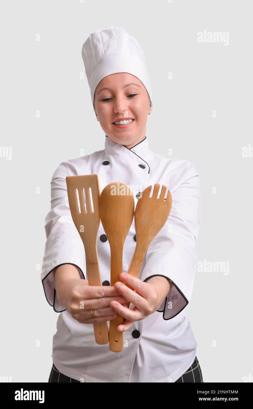 Professional chef holding wooden kitchen utensils, smiling, ready to ...