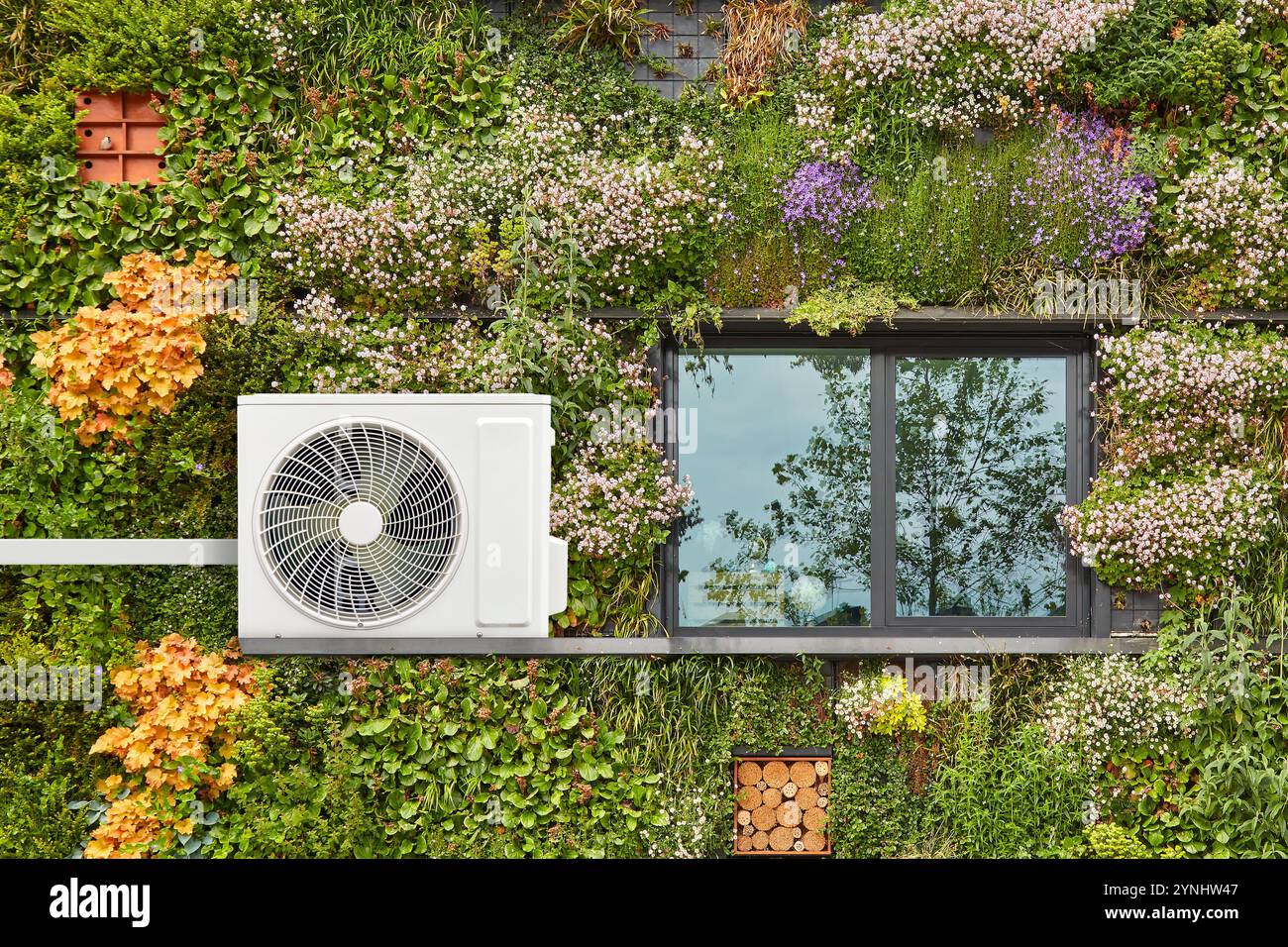 Air-source heat pump on a green sustainable building covered with ...