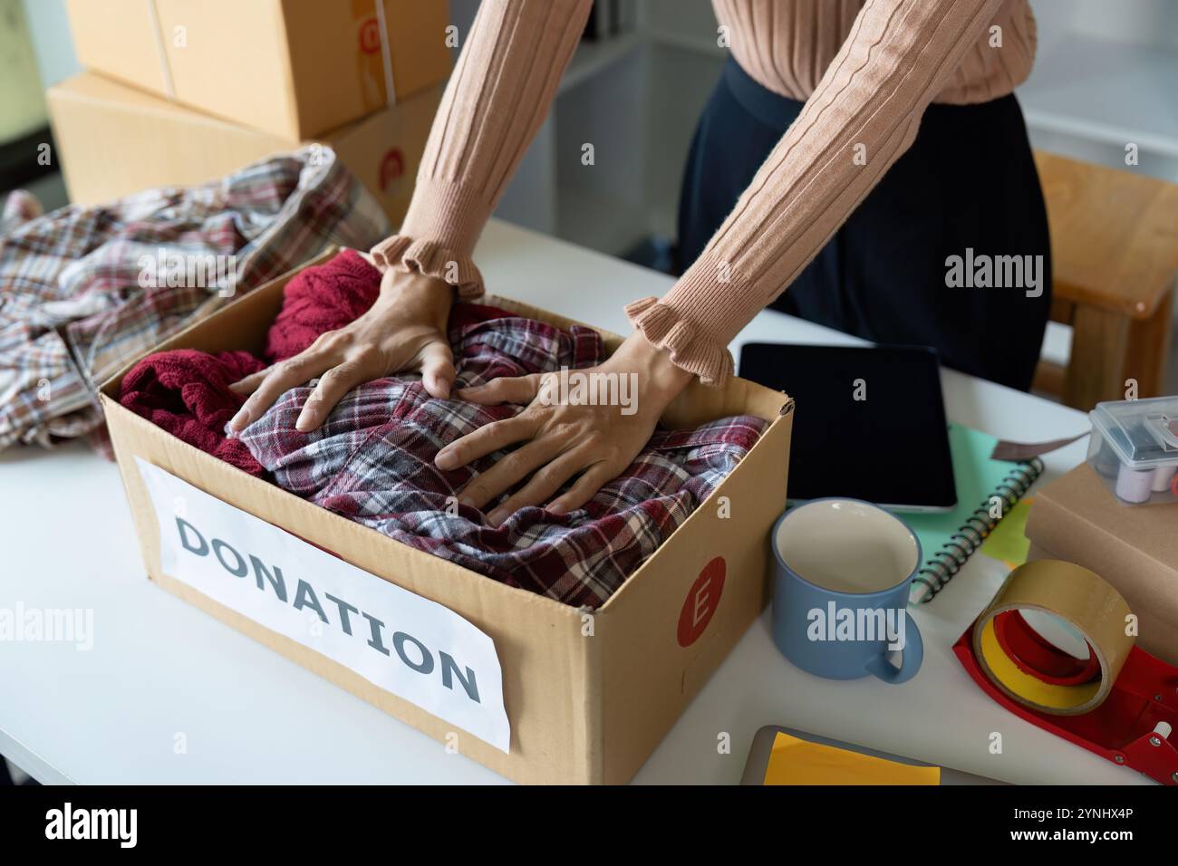 Hands Organizing Clothes in Donation Box for Charity and Community ...