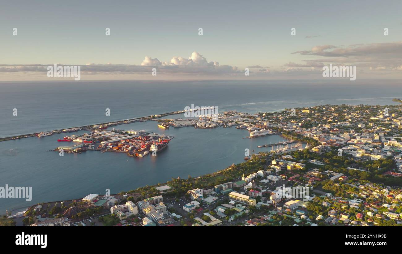 Papeete cityscape at golden hour sunset. Aerial view drone flight over ...