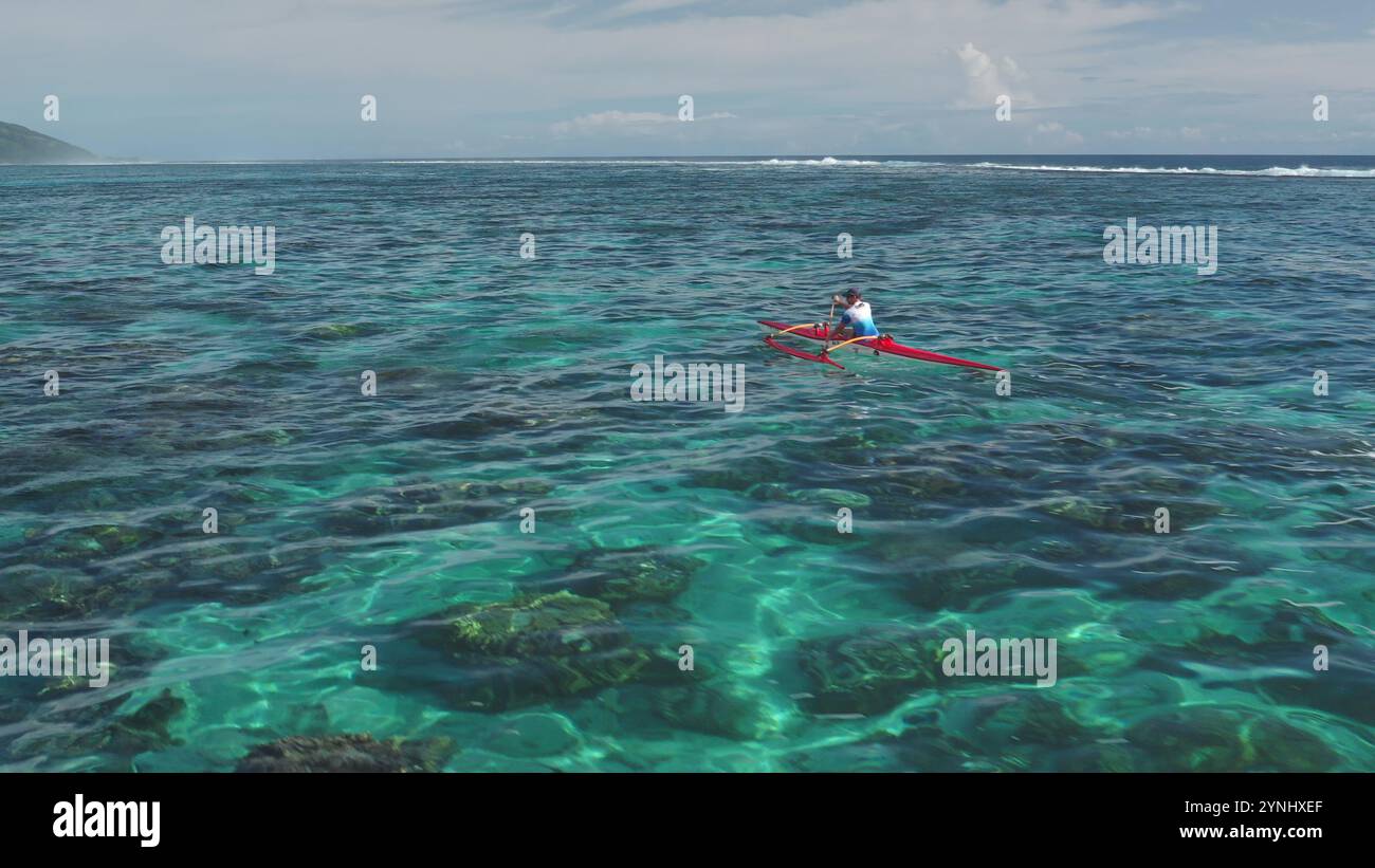 Aerial drone captures a sportsman kayaking in the crystal-clear ...