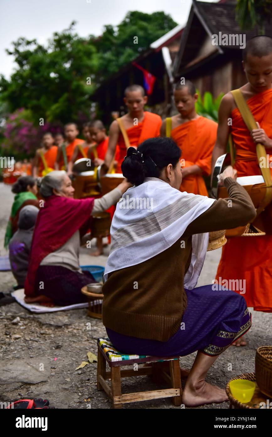 Faithfuls line the streets and offer food to passing monks every ...