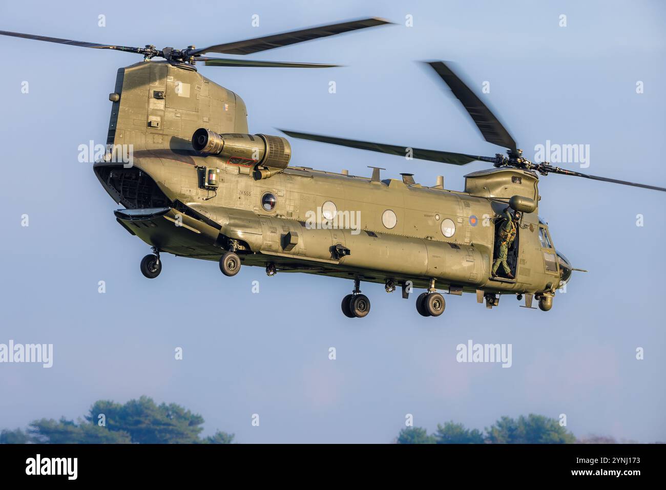 A Chinook helicopter soars through the sky with its iconic twin rotors ...