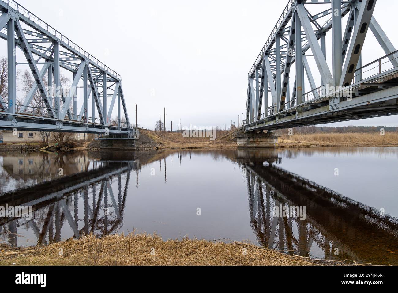 Two parallel metal truss bridges with railway tracks over the river ...