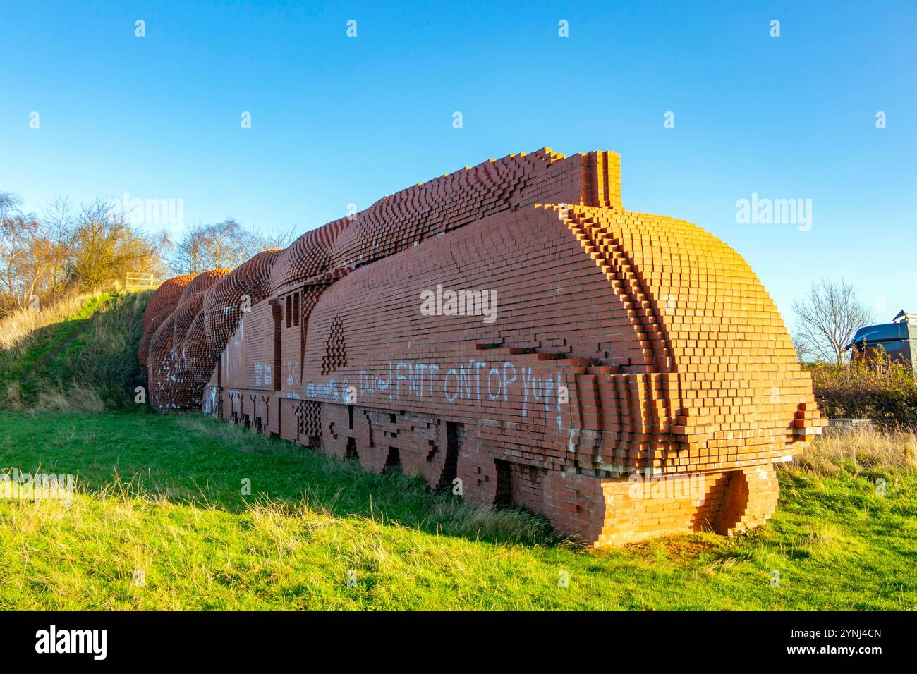 Unique red brick sculpture of a Mallard train in steam in an outdoor ...