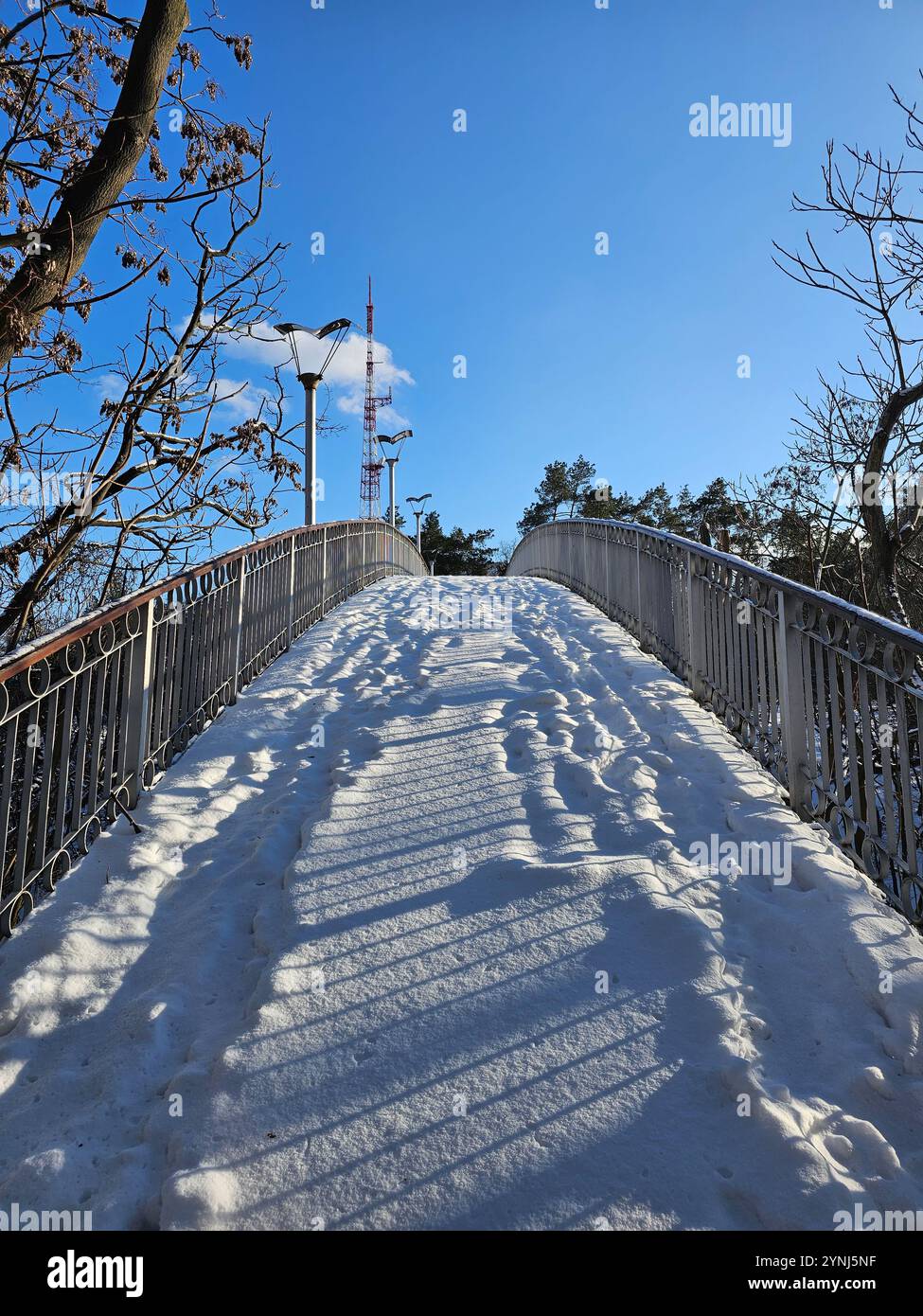 Footprints covering snow-filled pathway on bridge leading towards ...