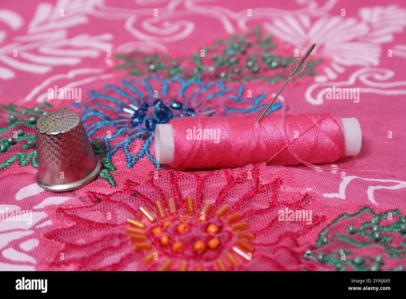 Spool of Pink Thread on Vintage Embroidered and Beaded Fabric Stock ...