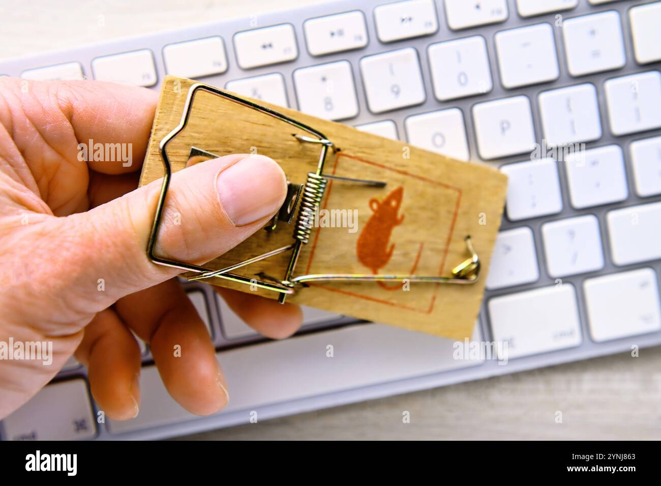 Hand in Mausefalle vor einer Computertastatur *** Hand in mousetrap in ...