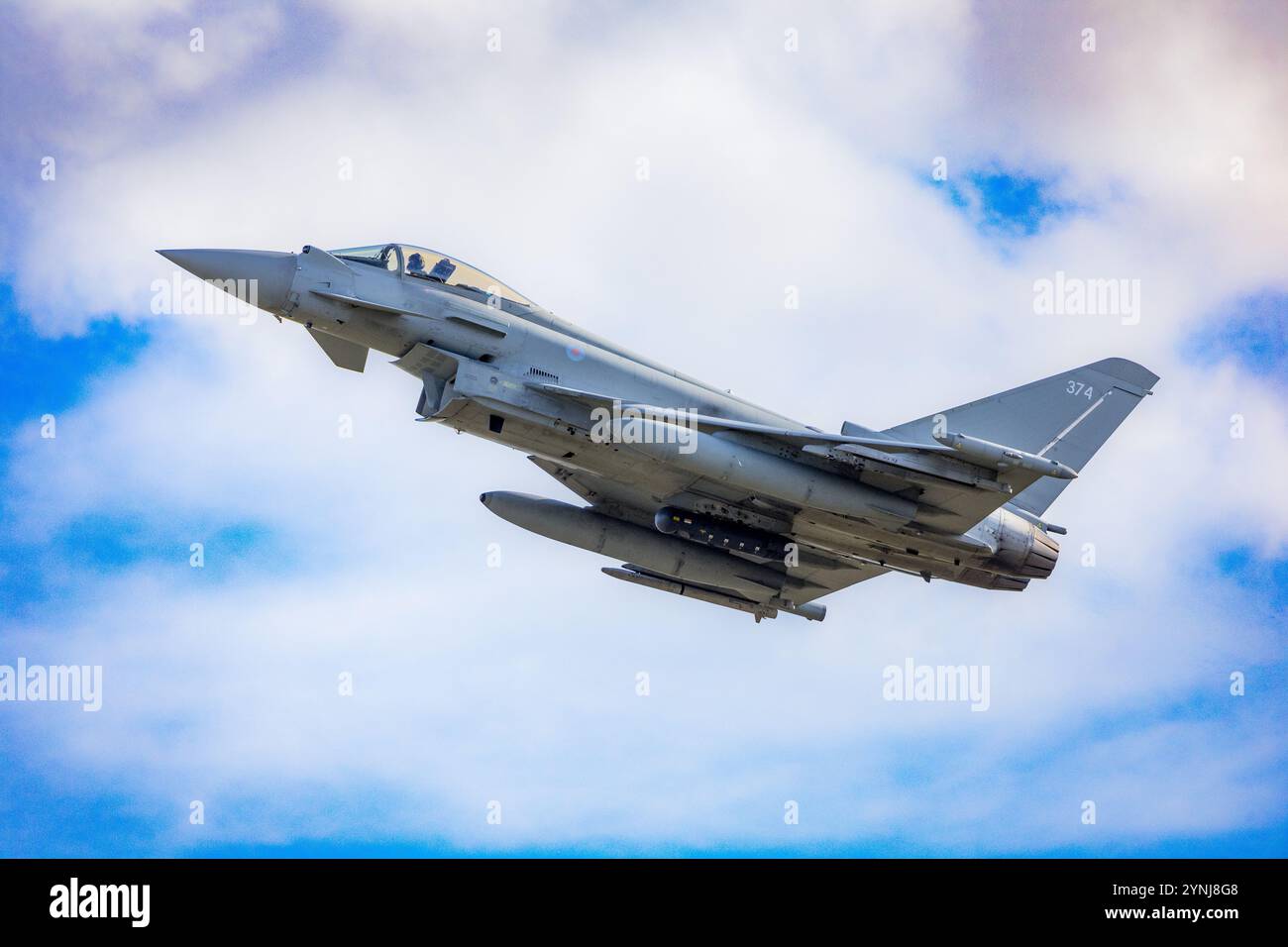 A Eurofighter Typhoon soars through a vibrant sky, equipped with ...