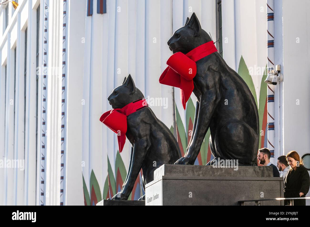 London, UK. 26 November, 2024. Two large sculptures of cats guarding ...