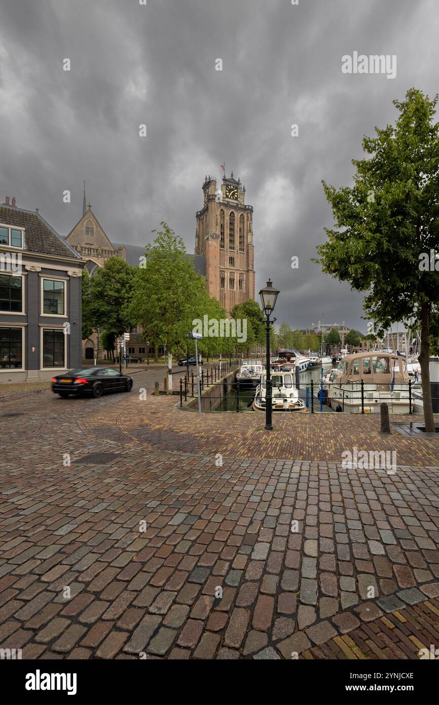 Historic European town with a clock tower under a dramatic cloudy sky ...