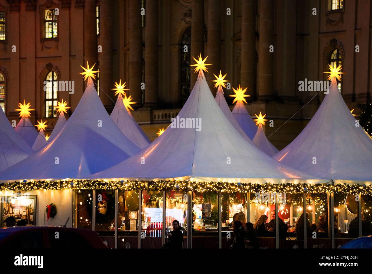 Christmas stars illuminate the top of the tents of the Christmas market ...