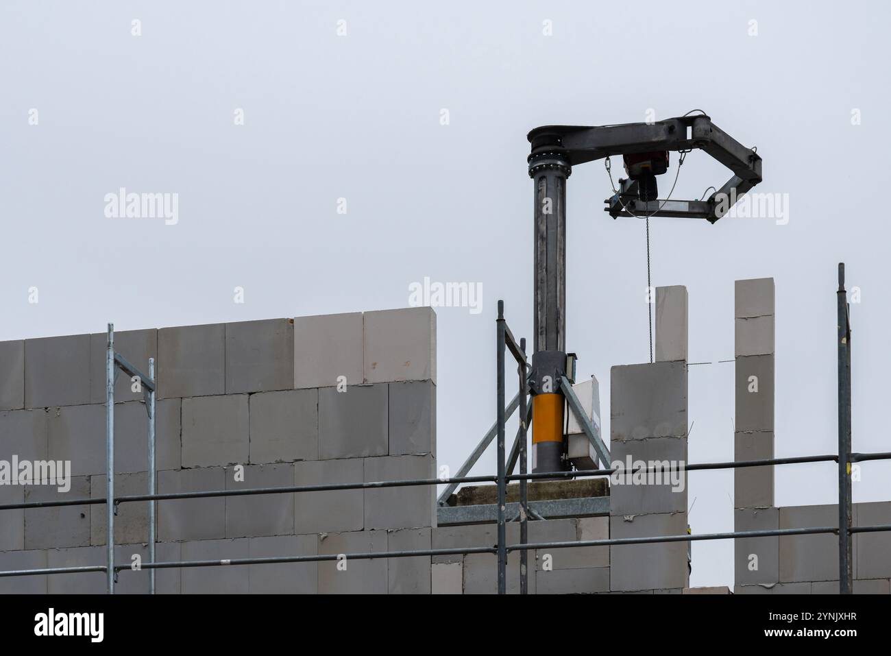 A construction robot efficiently places concrete blocks on a building ...