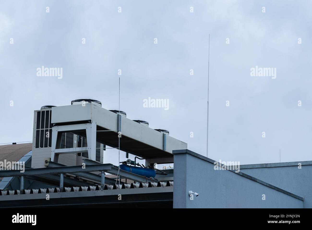 A rooftop features a cooling system with multiple units and antennas ...