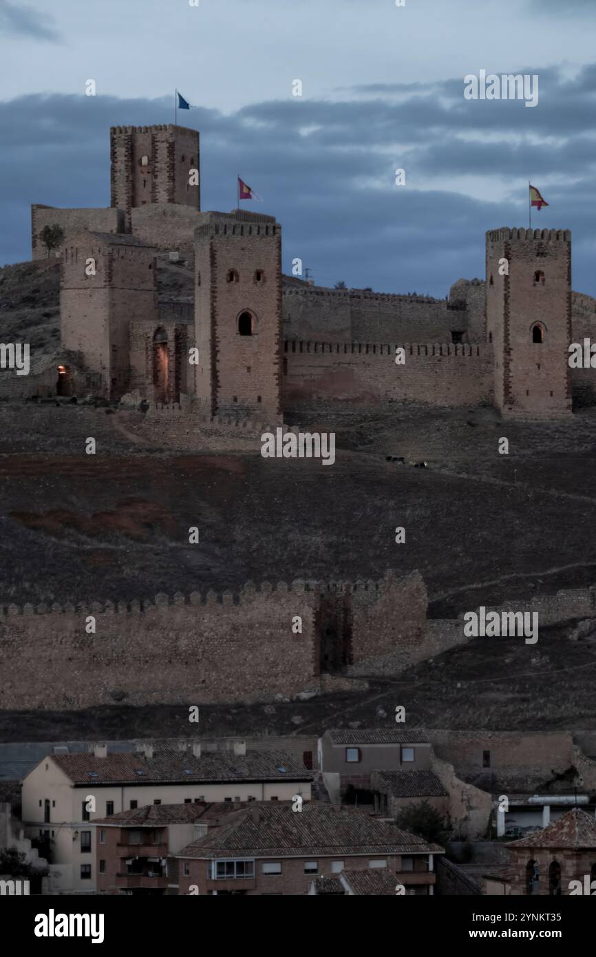 Towering medieval castle with fortified walls overlooking a small ...