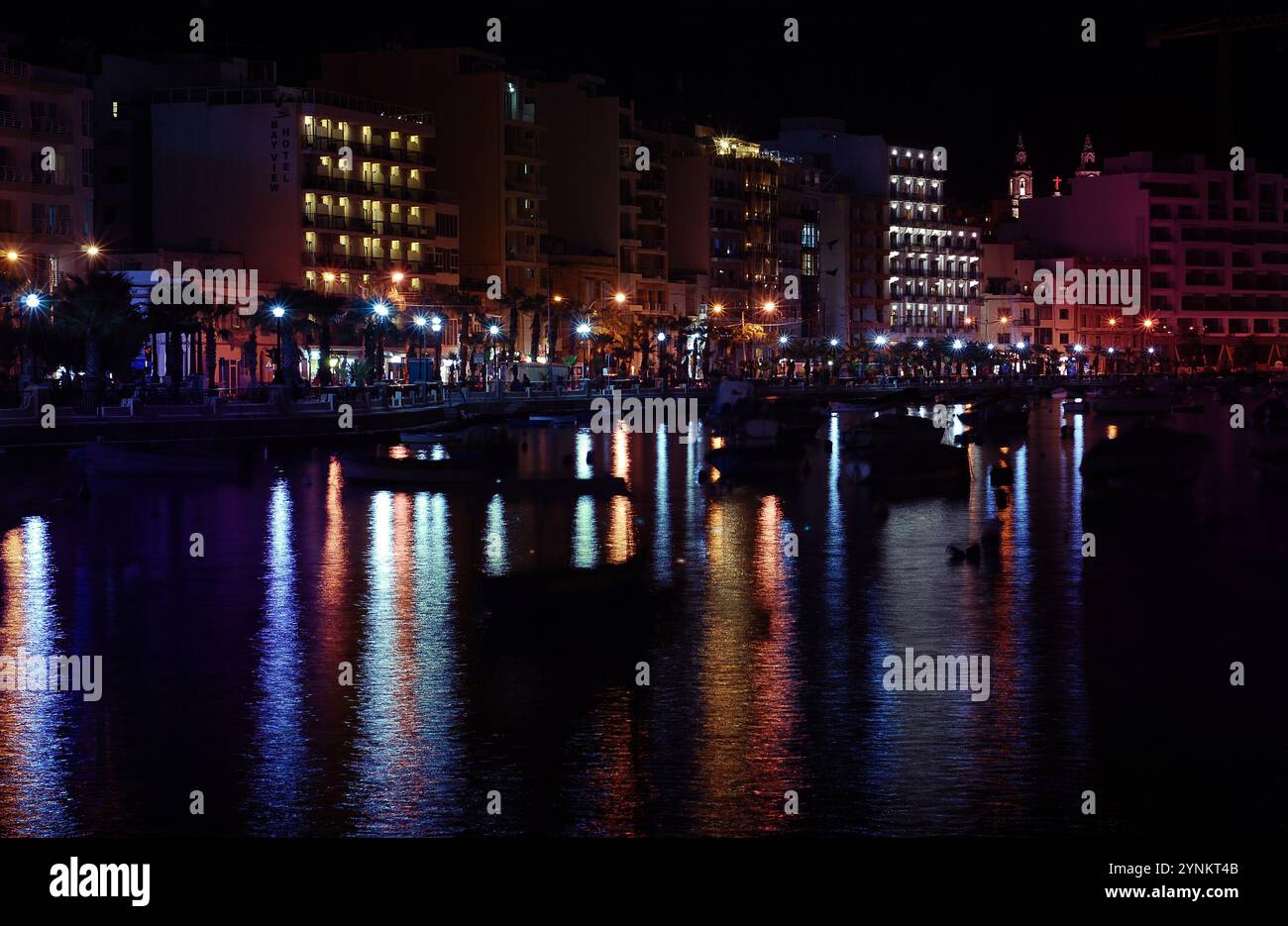 Vibrant waterfront promenade with illuminated buildings at night Stock ...