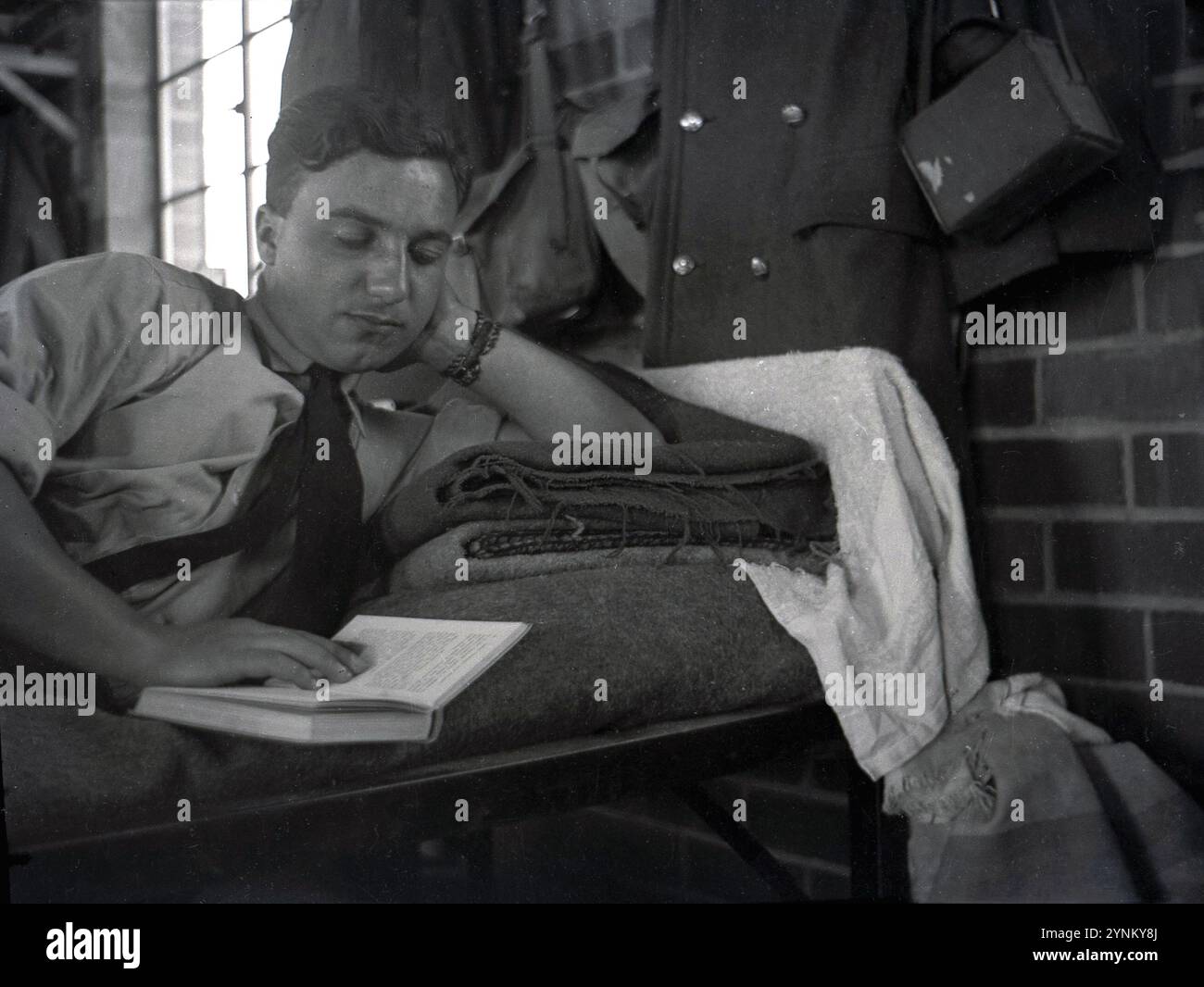 circa 1940s, historical, a British solider lying on a metal or camp bed ...