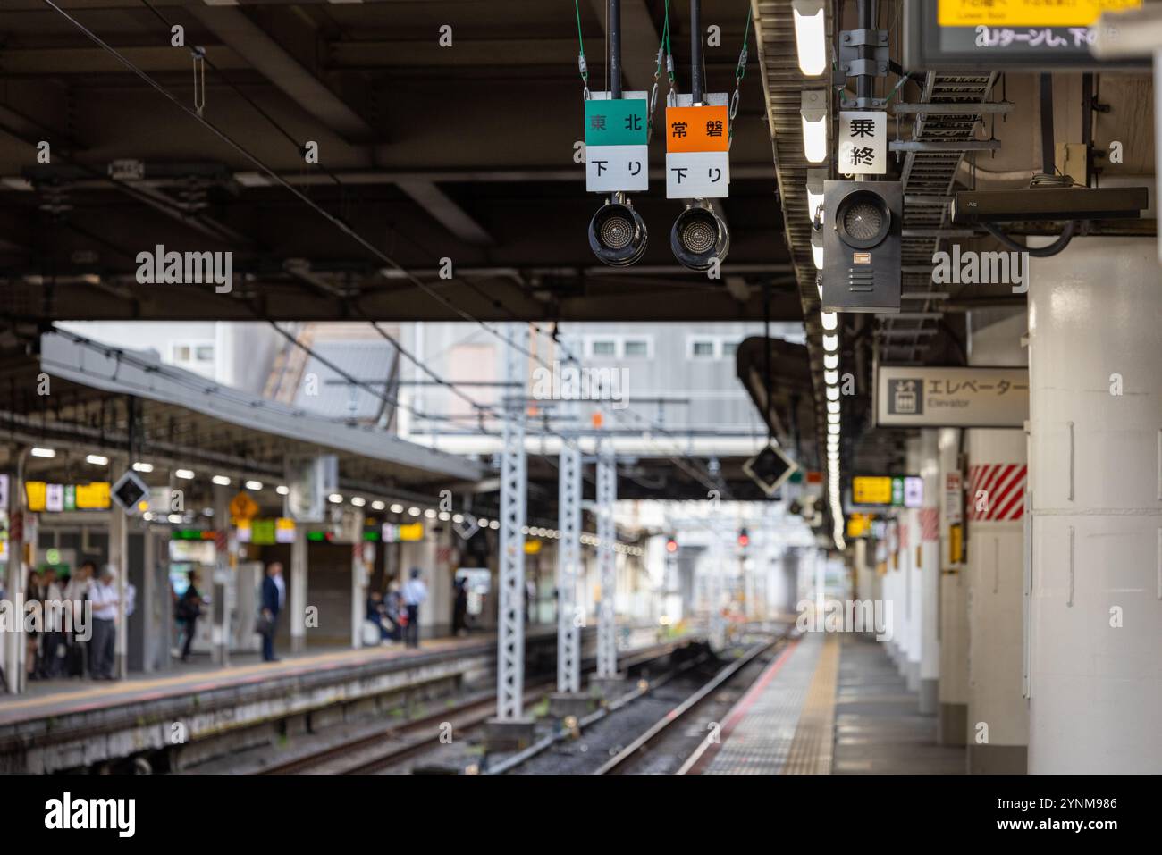 Tokyo train station platform with overhead signs and tracks Stock Photo ...