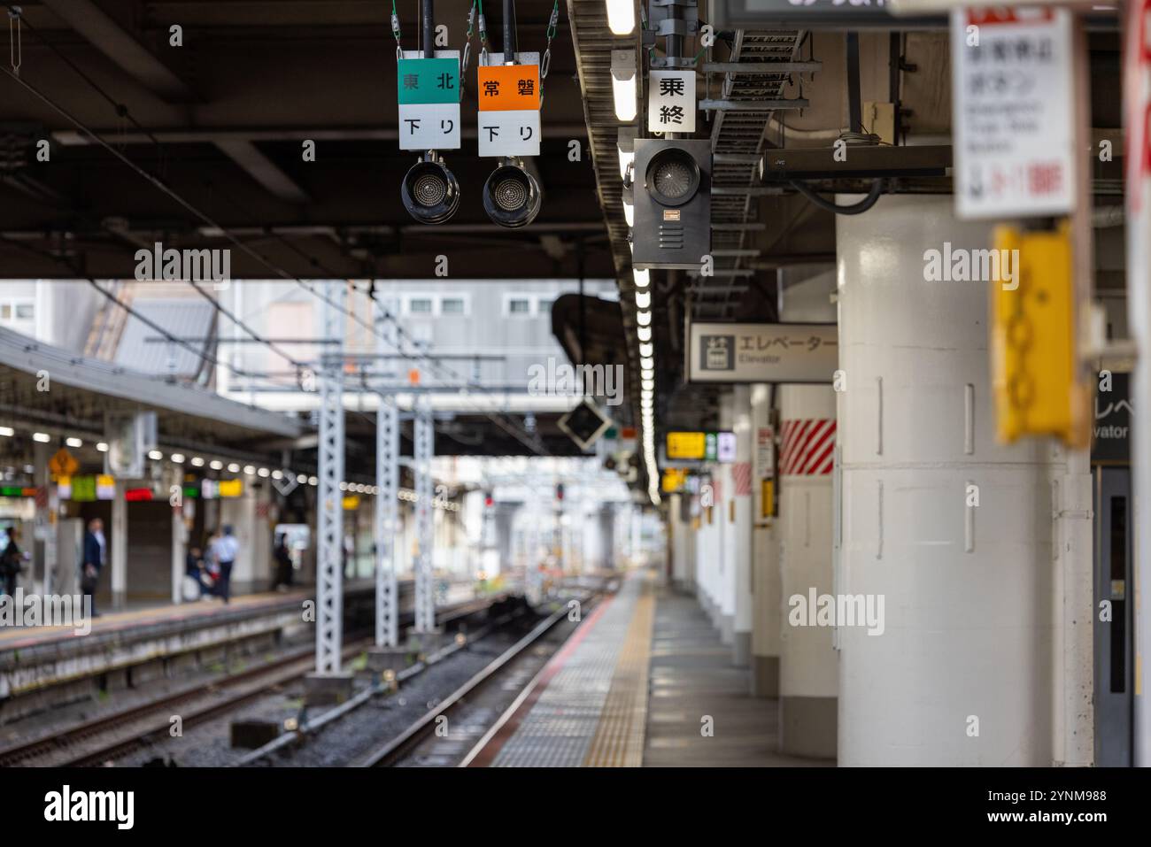 Empty train station platform with overhead signage and tracks Stock ...