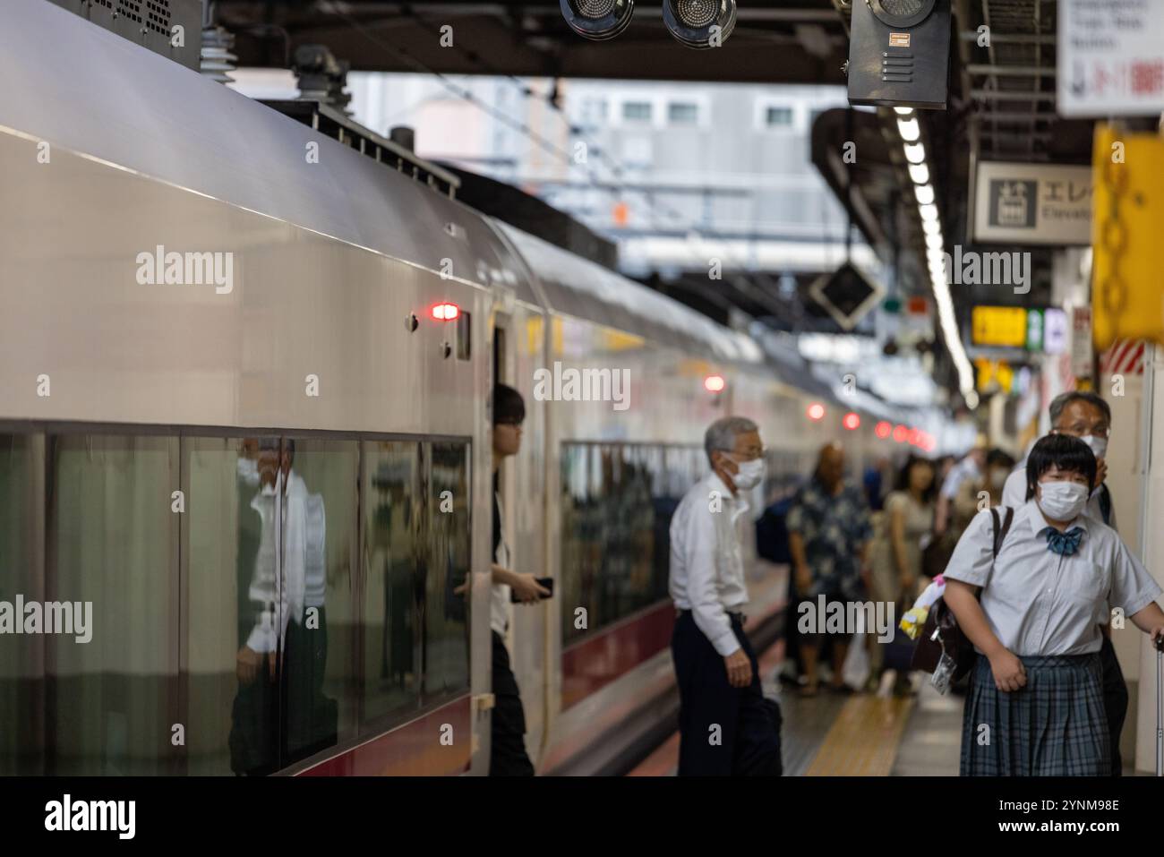 Passengers boarding and alighting a train at a station platform Stock ...