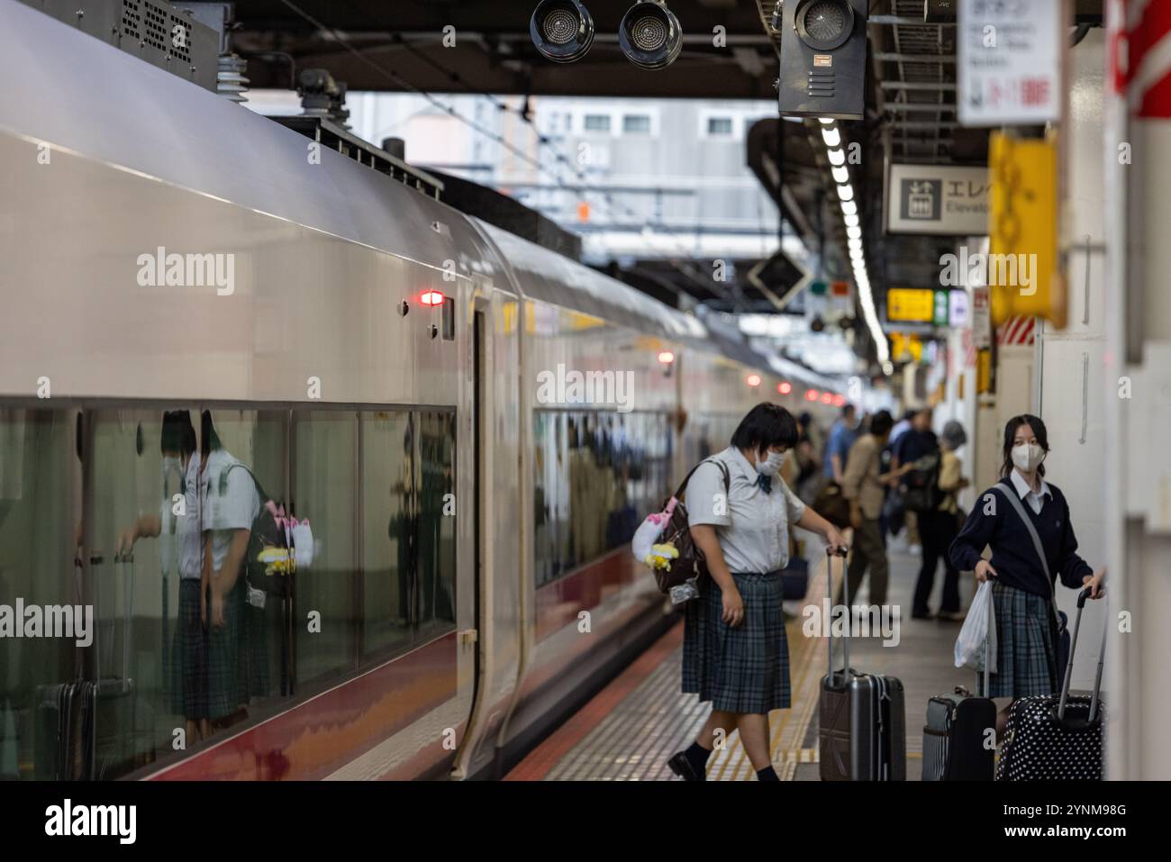 Passengers boarding a train at a busy station platform Stock Photo - Alamy