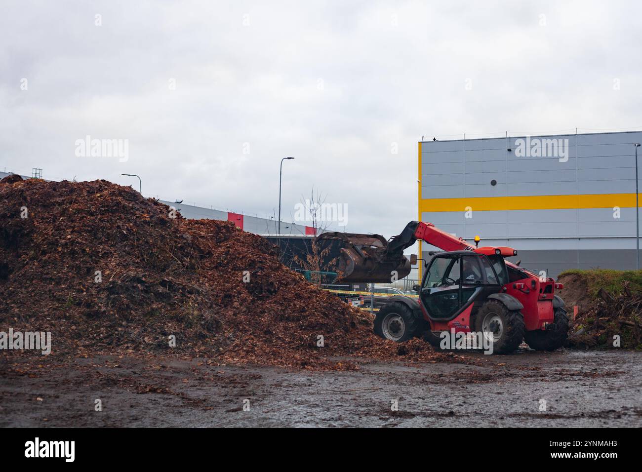 Tractor is working at the city green waste dump Stock Photo - Alamy