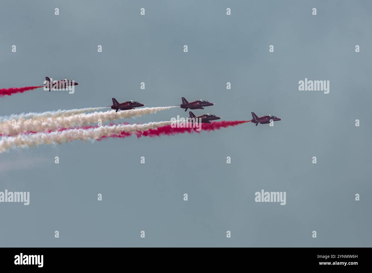 Five Red Arrows jets soar in a tight formation, trailing vibrant red ...