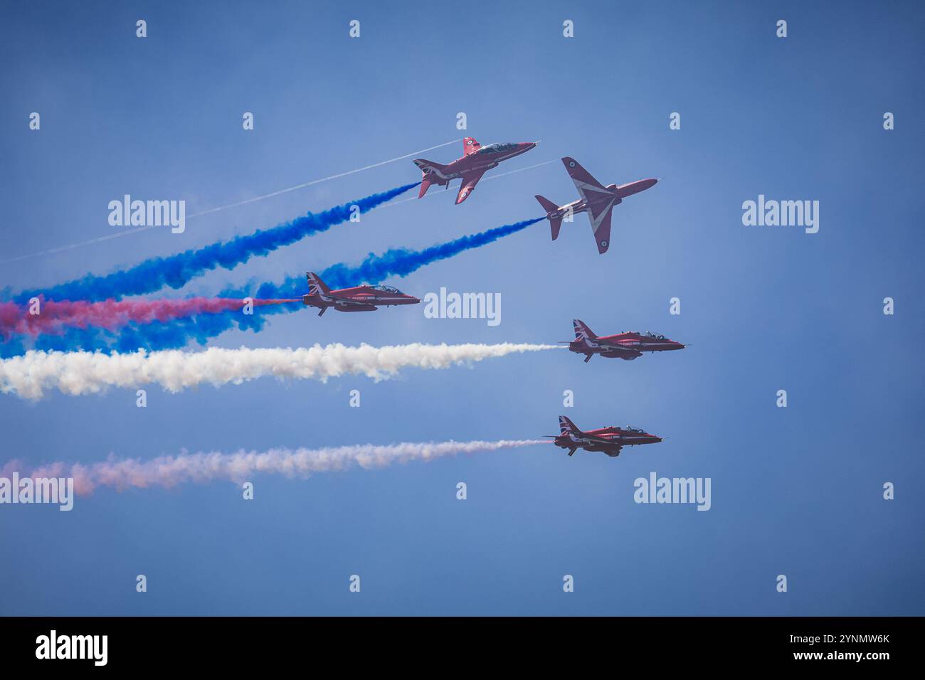 The Red Arrows execute a split formation maneuver, leaving trails of ...