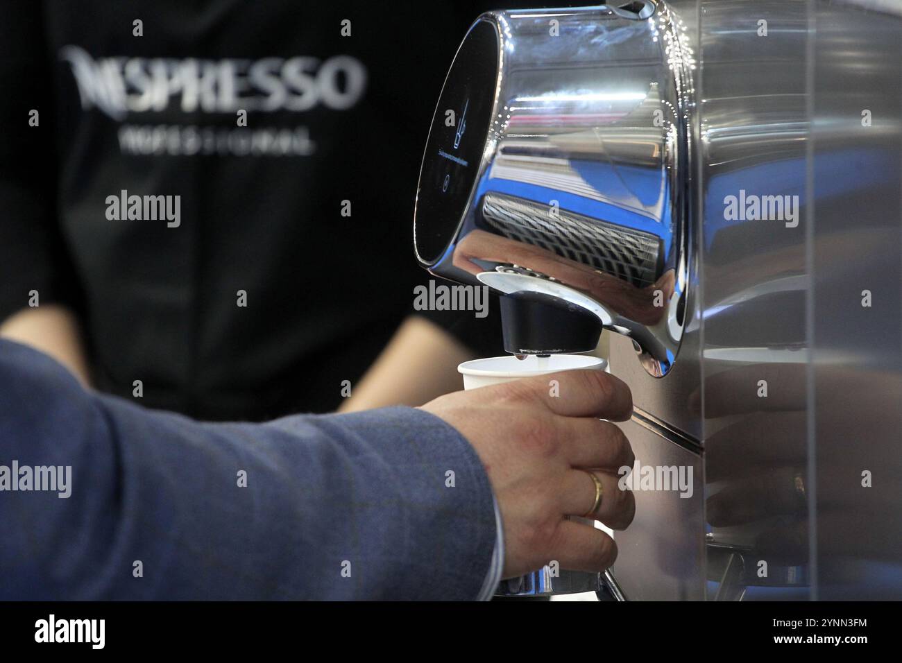 Fresh espresso dripping into a Nespresso-branded paper cup Stock Photo ...