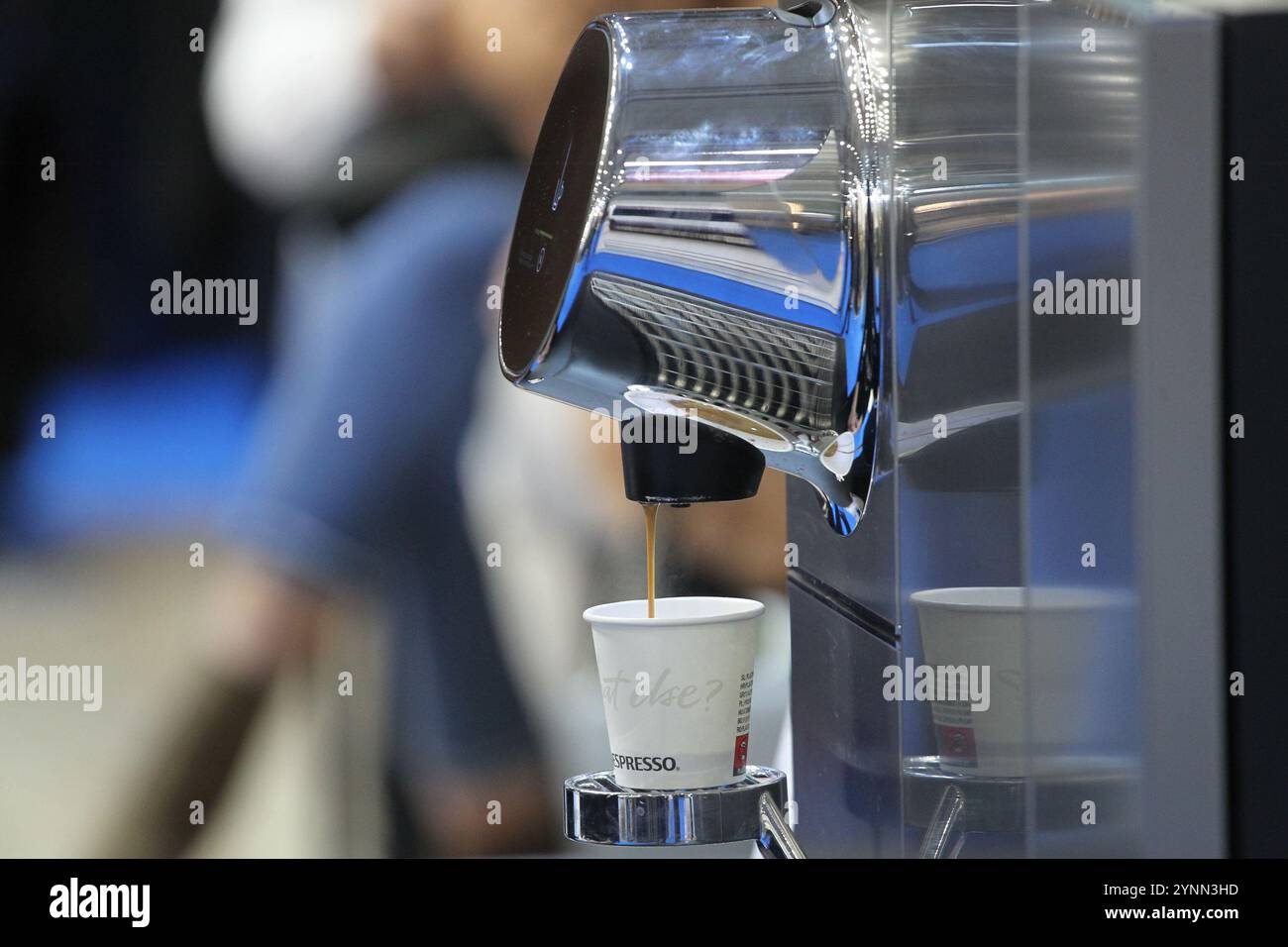 Fresh espresso dripping into a Nespresso-branded paper cup Stock Photo ...