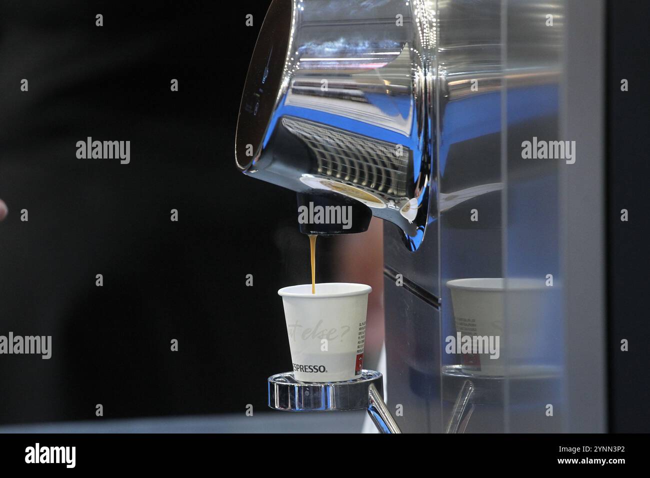 Fresh espresso dripping into a Nespresso-branded paper cup Stock Photo ...