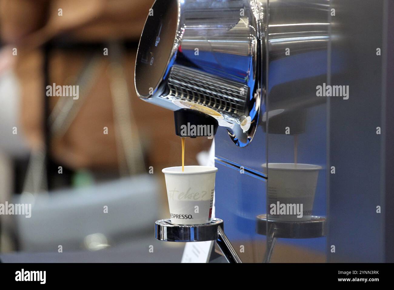Fresh espresso dripping into a Nespresso-branded paper cup Stock Photo ...