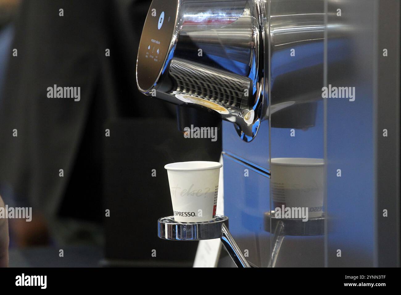 Fresh espresso dripping into a Nespresso-branded paper cup Stock Photo ...
